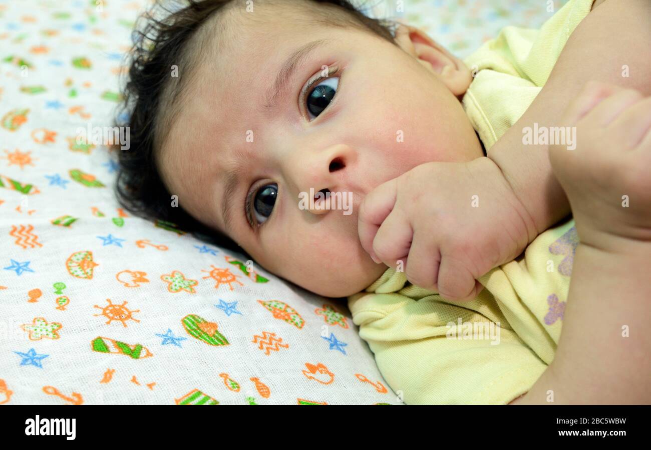 Newborn baby playing on bed Stock Photo - Alamy
