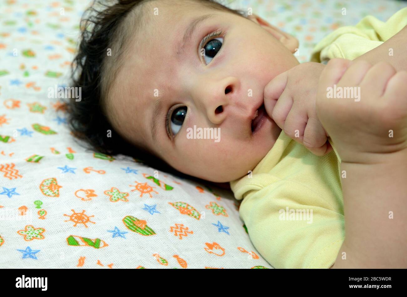 Newborn baby playing on bed Stock Photo - Alamy