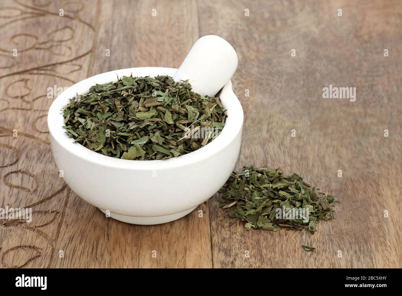 Bogbean herb leaf in a mortar with pestle used in herbal medicine to ...