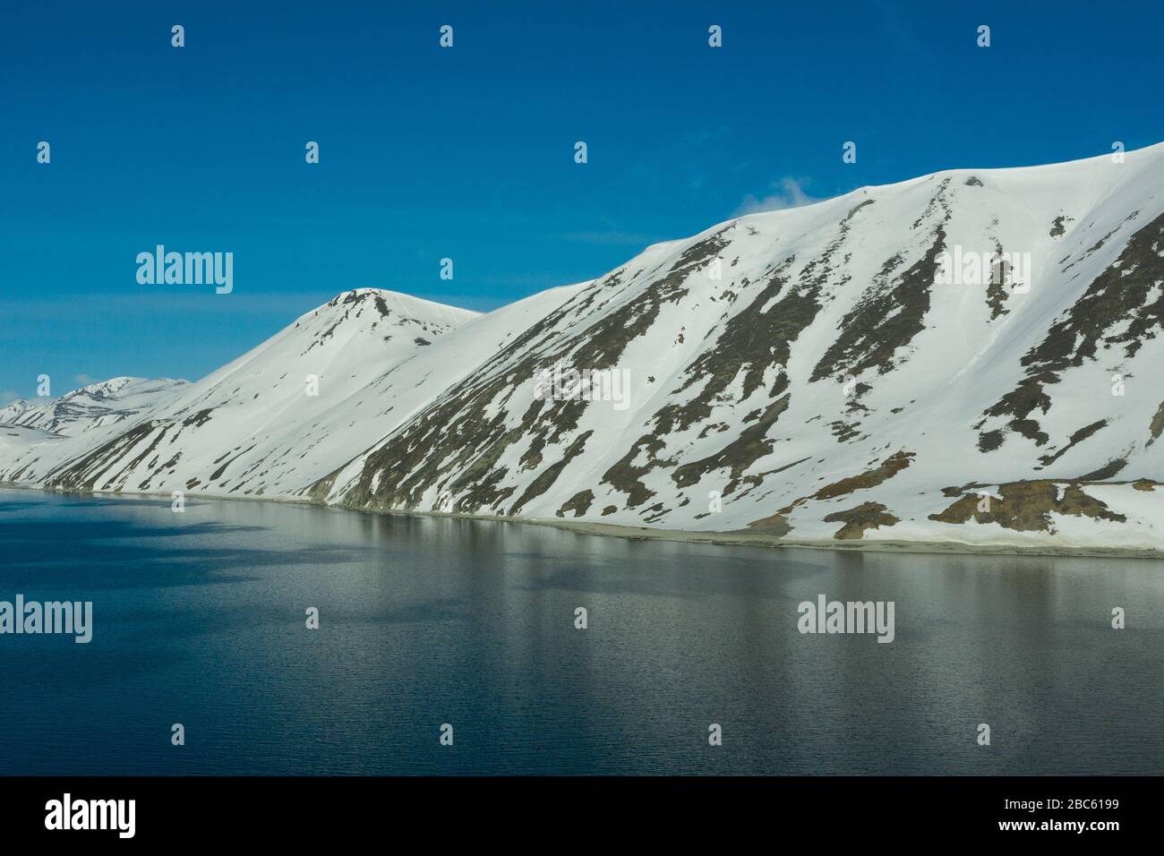 The mountainous sea coast covered with snow in a sunny weather. Place ...