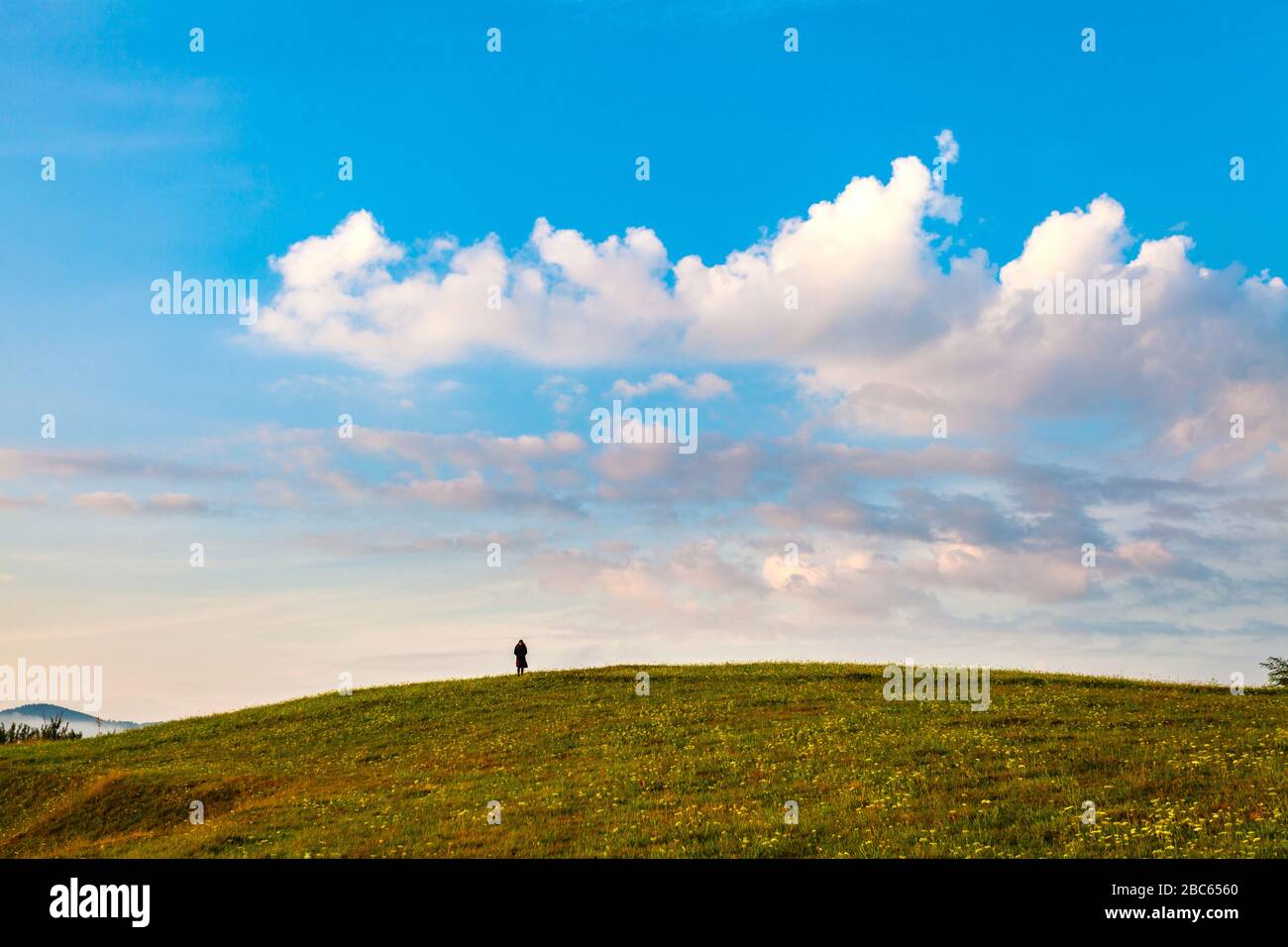 Round hill with beautiful clouds and silhouette Stock Photo - Alamy