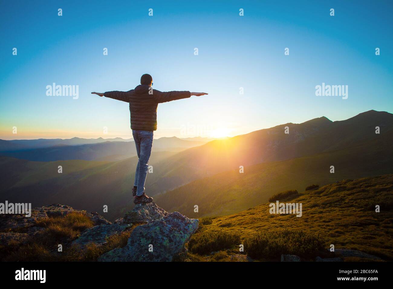 Man on the edge of the cliff, outstretched arms, feeling the freedom ...