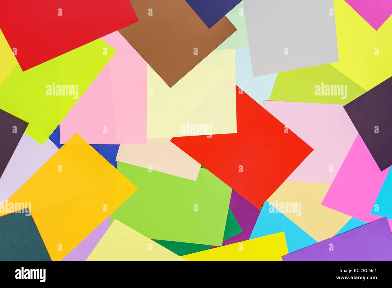 A multi-colored kaleidoscope of colored sheets of paper scattered ...