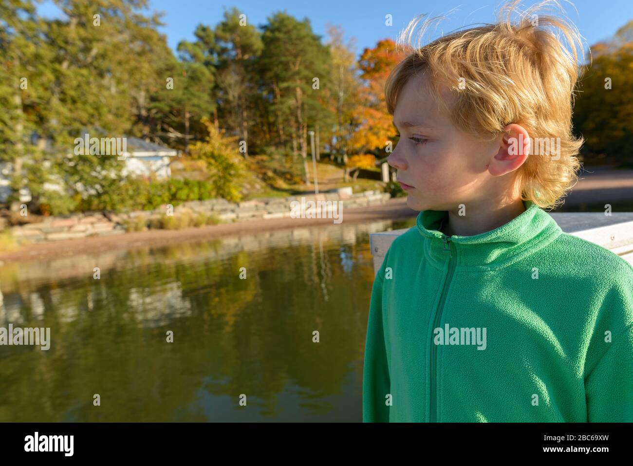 Profile view of young handsome boy against view of the forest by the ...
