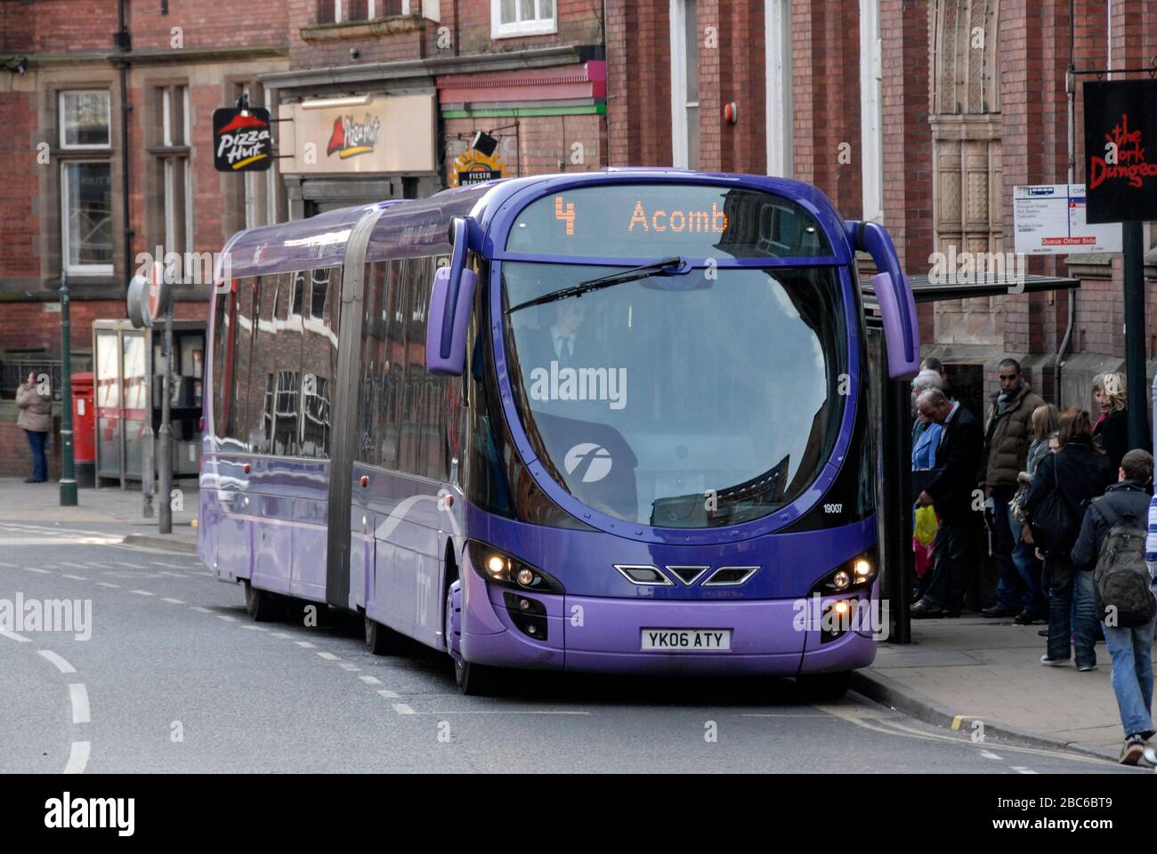 A bendy bus in service in one of the narrow streets of York, in ...