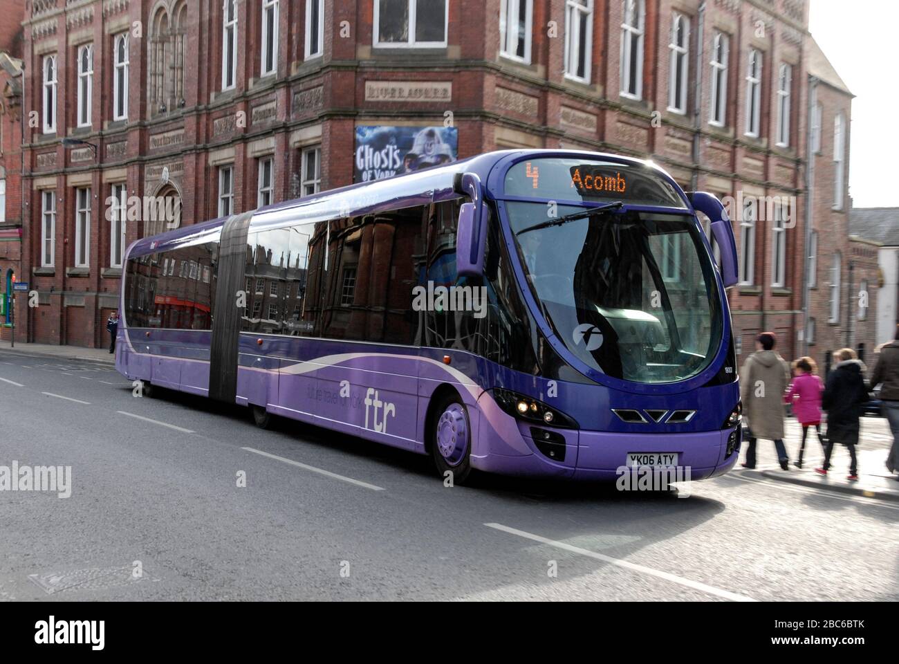 A bendy bus in service in one of the narrow streets of York, in ...