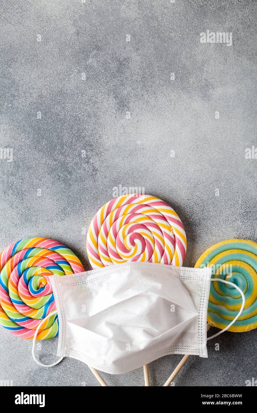 multi colored lollipops covered medical mask top view flat lay copy ...