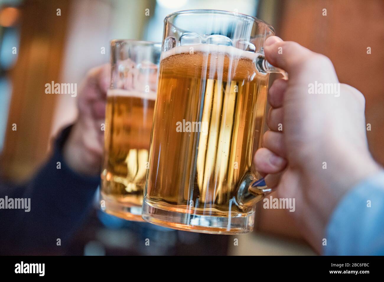 Close-up of two men toasting with beer Stock Photo - Alamy