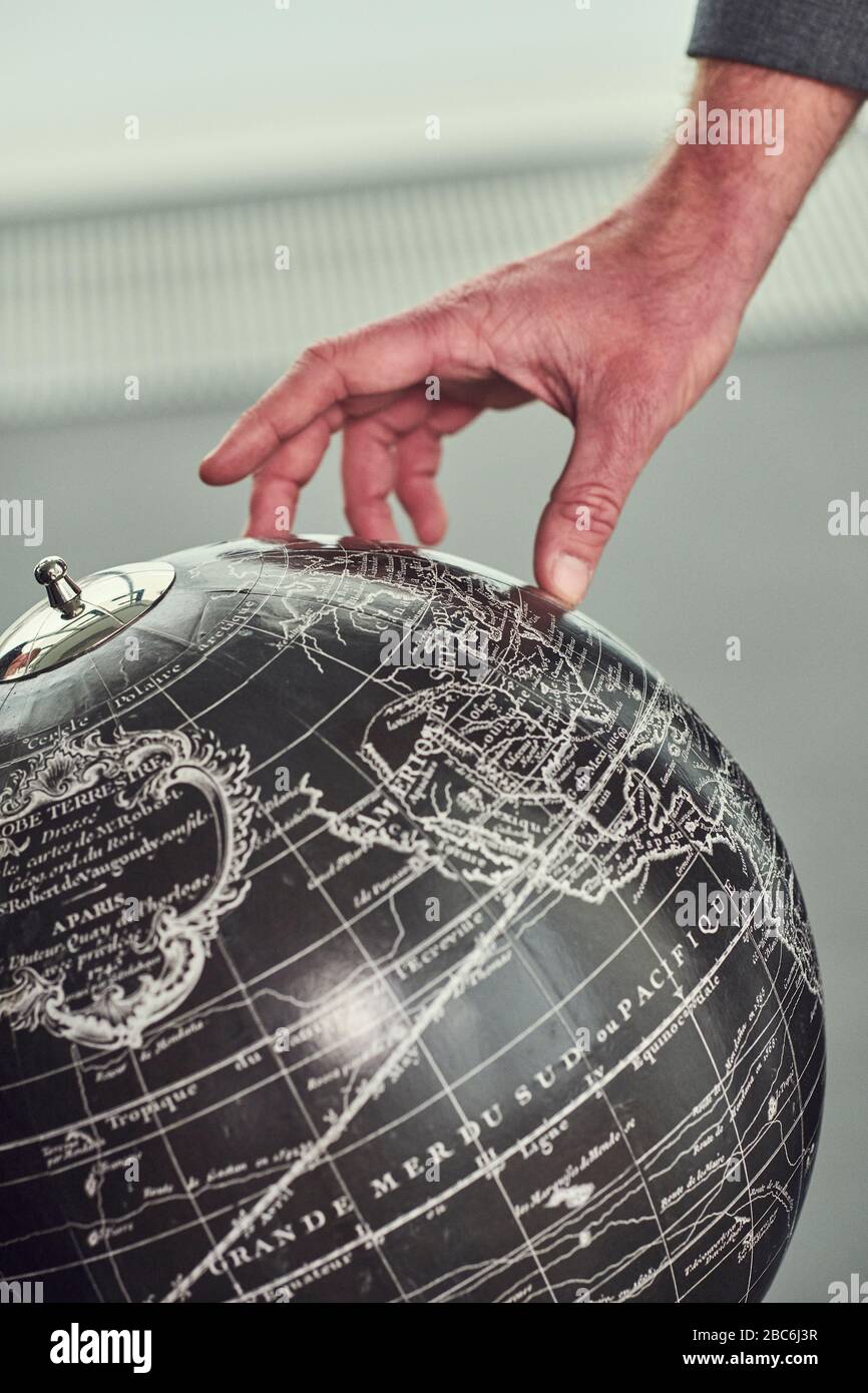 Hand scrolling on retro style world map Stock Photo - Alamy