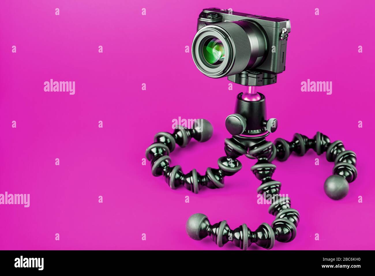 Professional camera on a tripod, on a pink background. Record videos ...