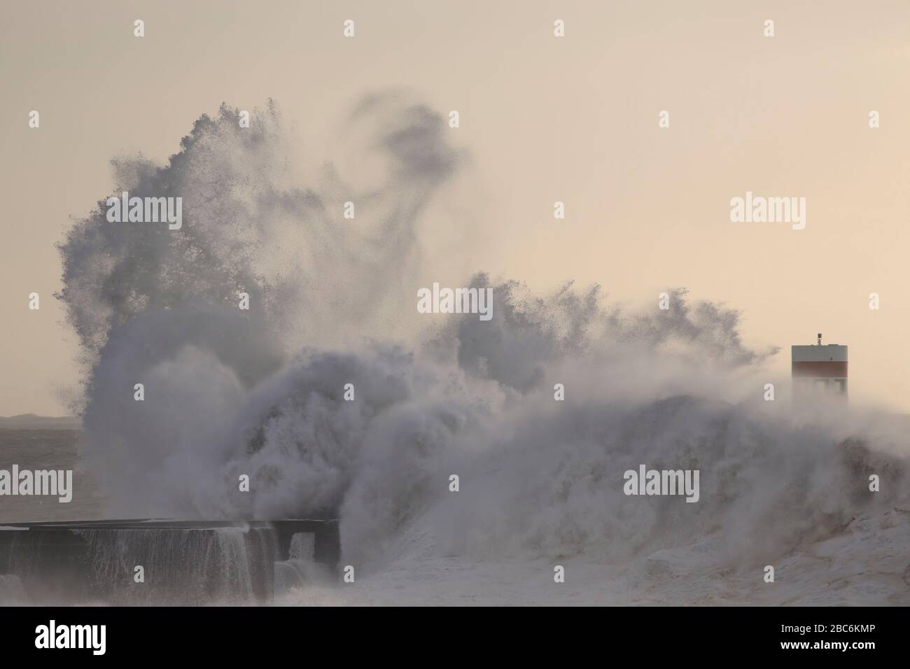 Backlit big wave splash at sunset. Douro river mouth south pier and ...