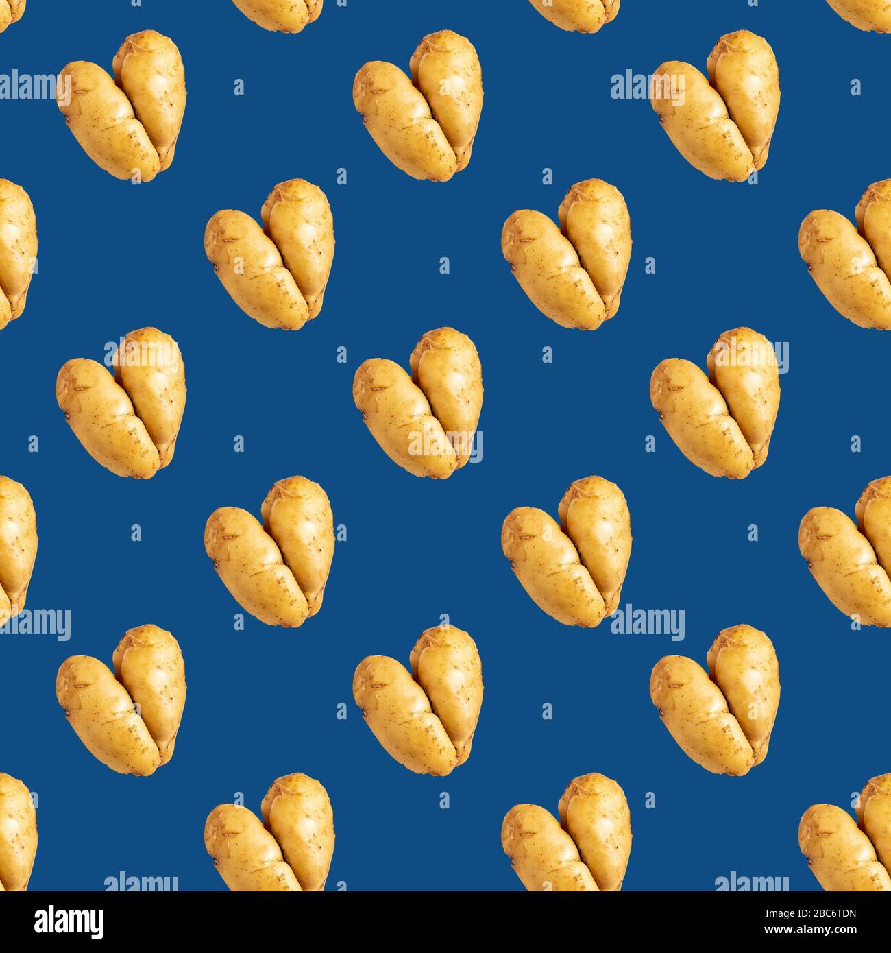 Flat lay Seamless Pattern made with ugly potato over classic blue color ...