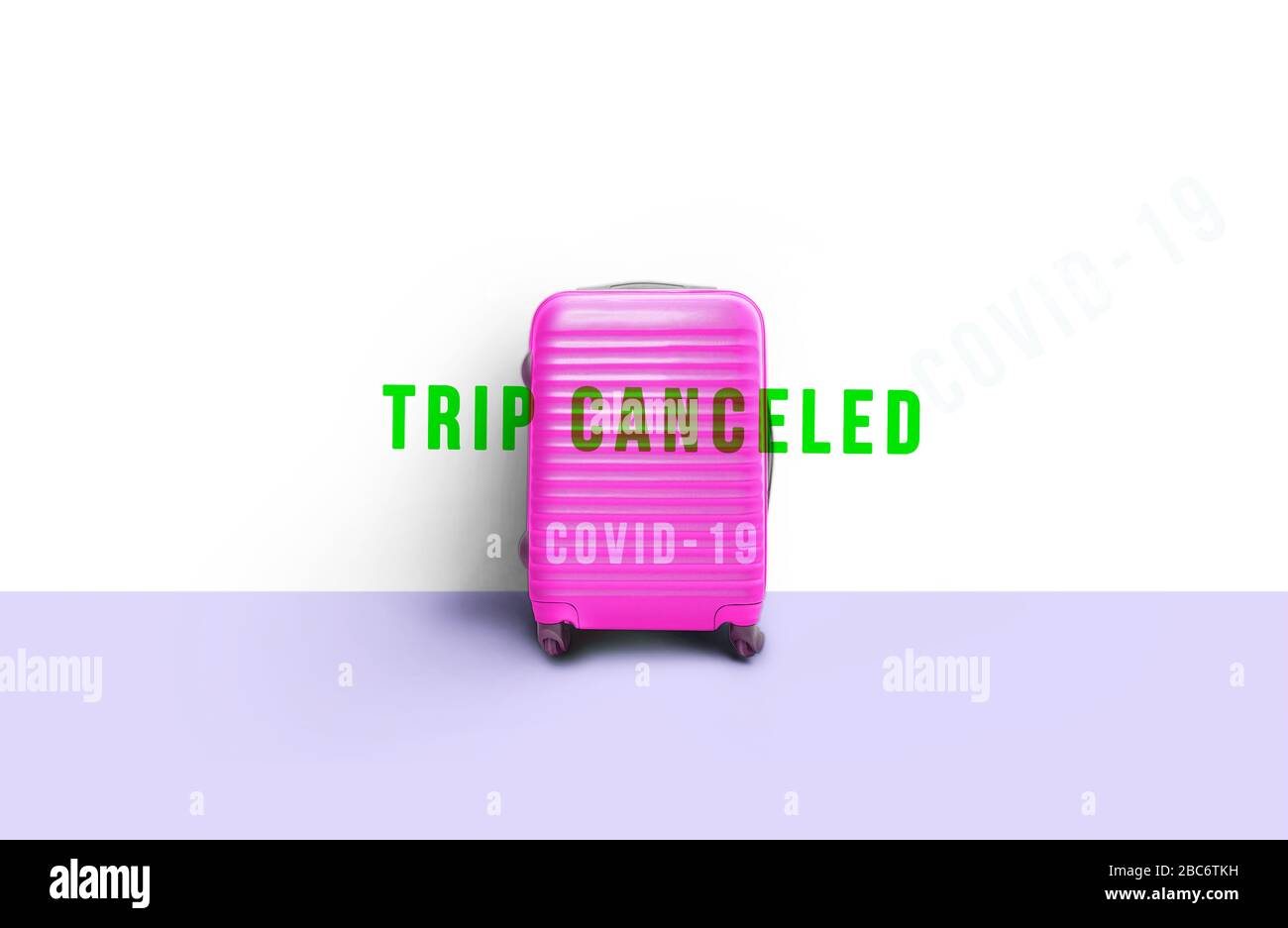 Pink suitcase standing next to wall with message. Stop travel to risk ...