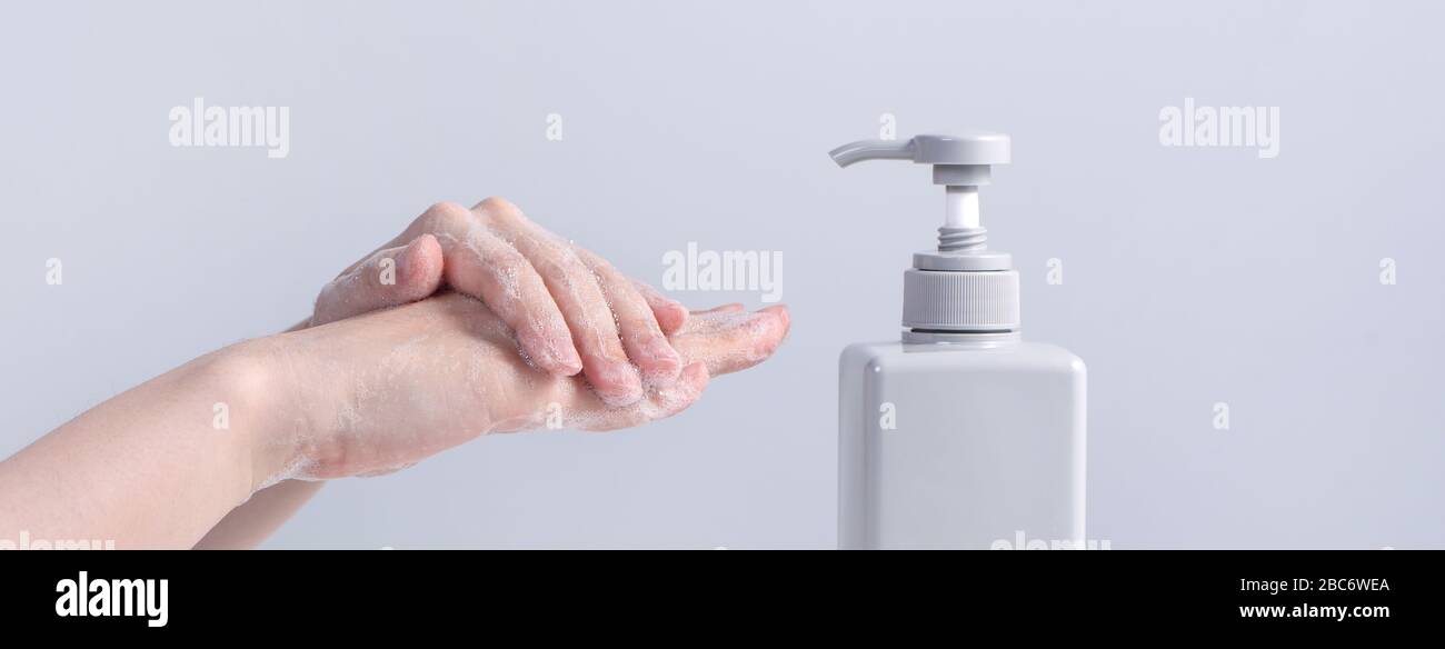 Washing hands. Asian young woman using liquid soap to wash hands ...