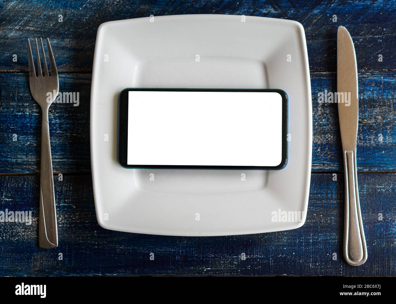 Mobile smart phone served as dinner on white plate. Concept of ...