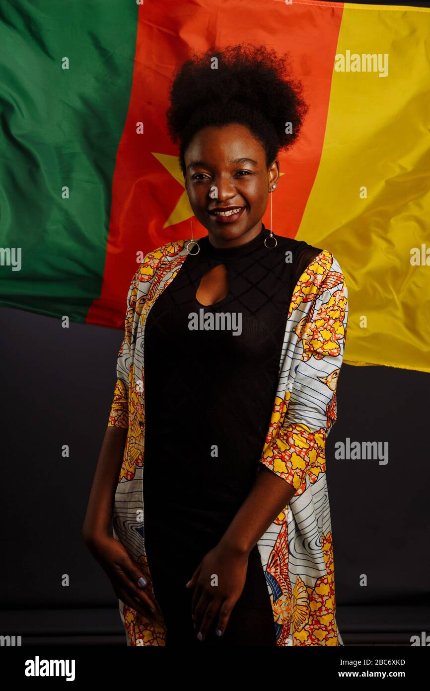Smiling african girl from Cameroon on the background of the flag of her ...