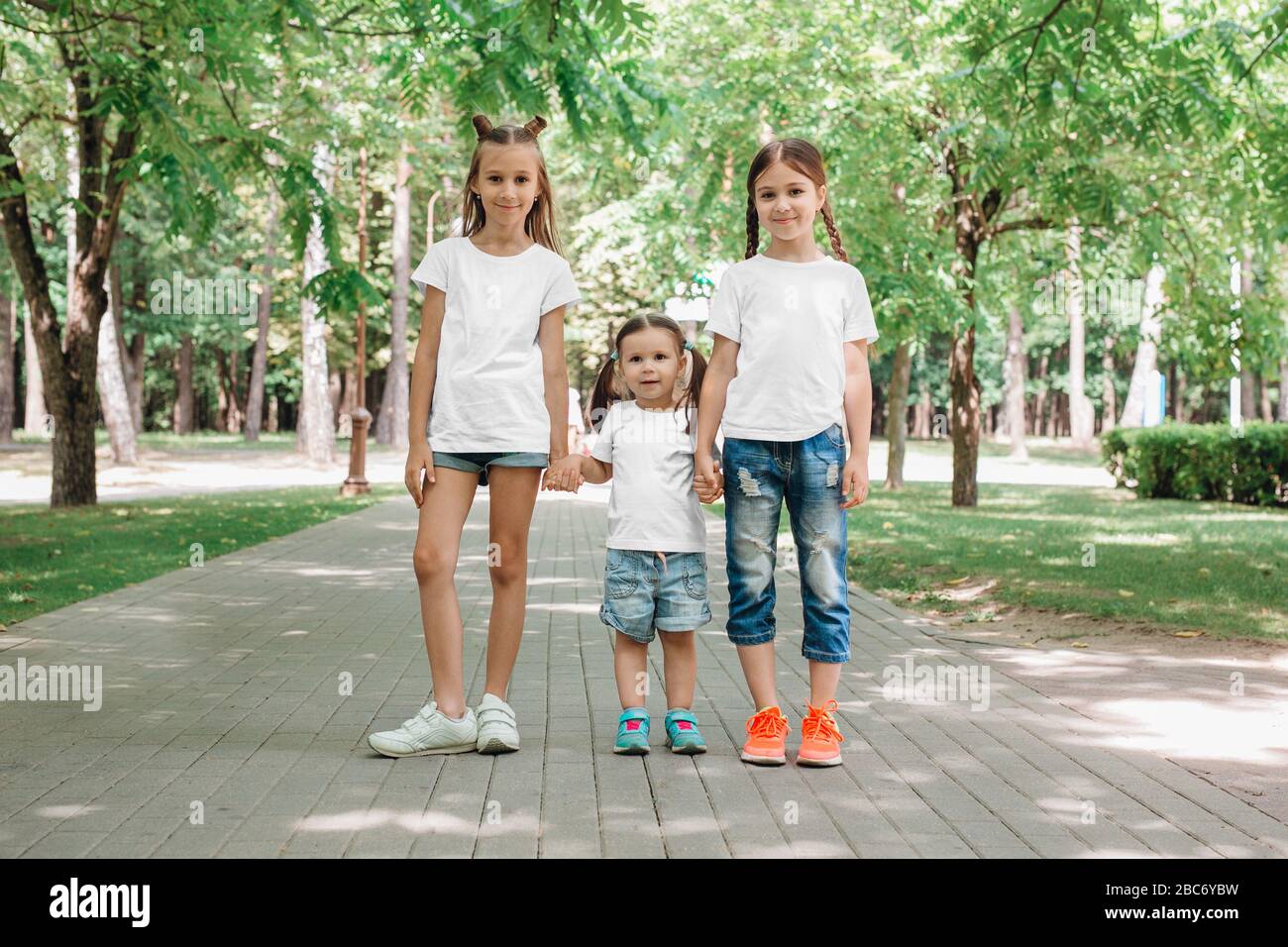Three children stand hi-res stock photography and images - Alamy