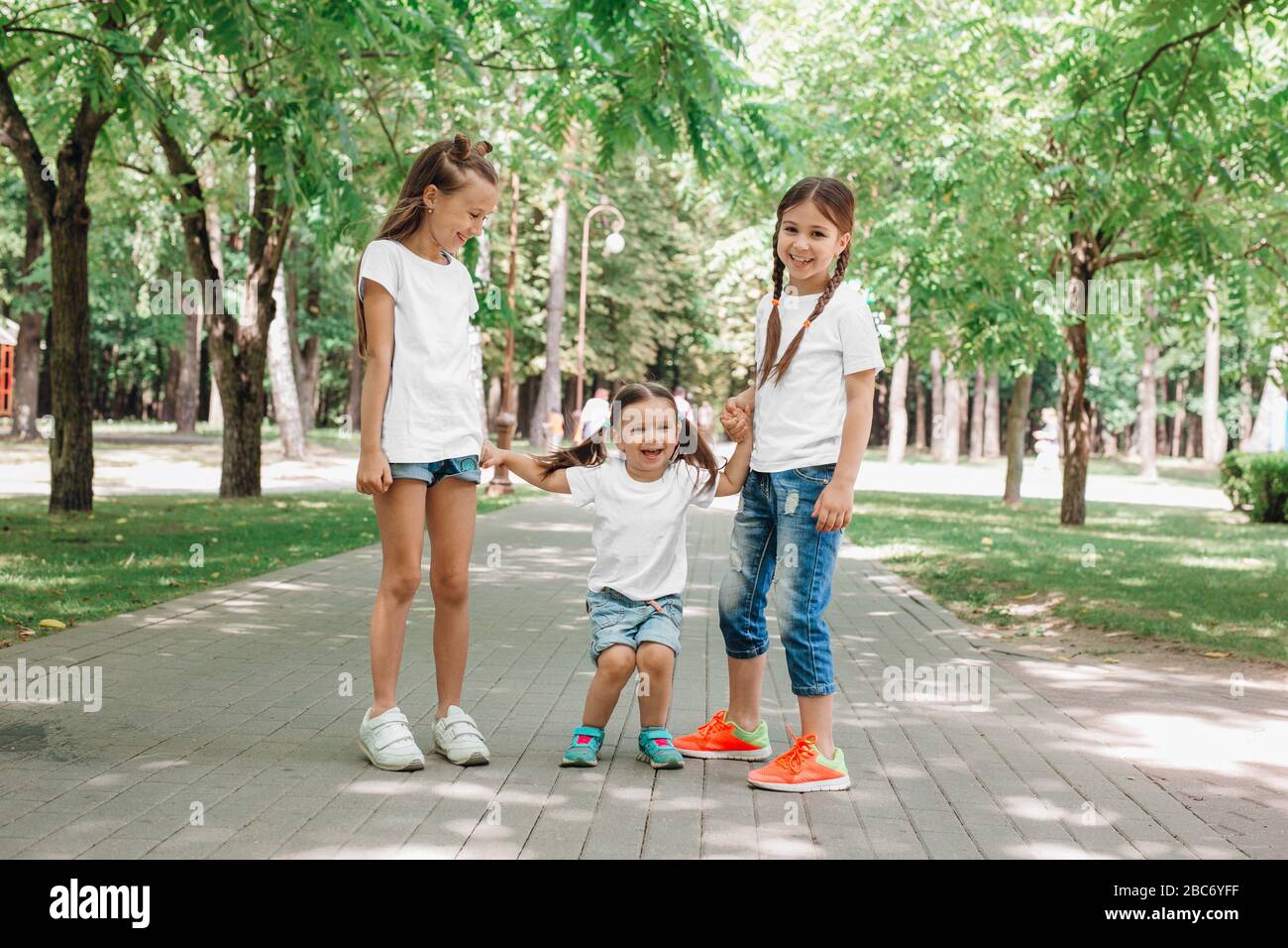 Three children stand hi-res stock photography and images - Alamy