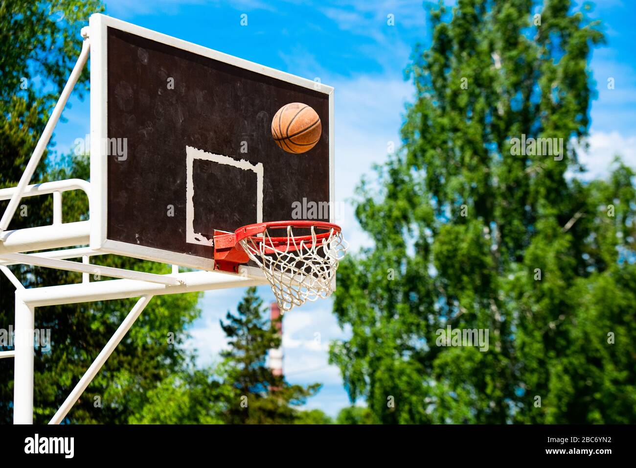 Basketball hoop in the park with green trees as background Stock Photo ...