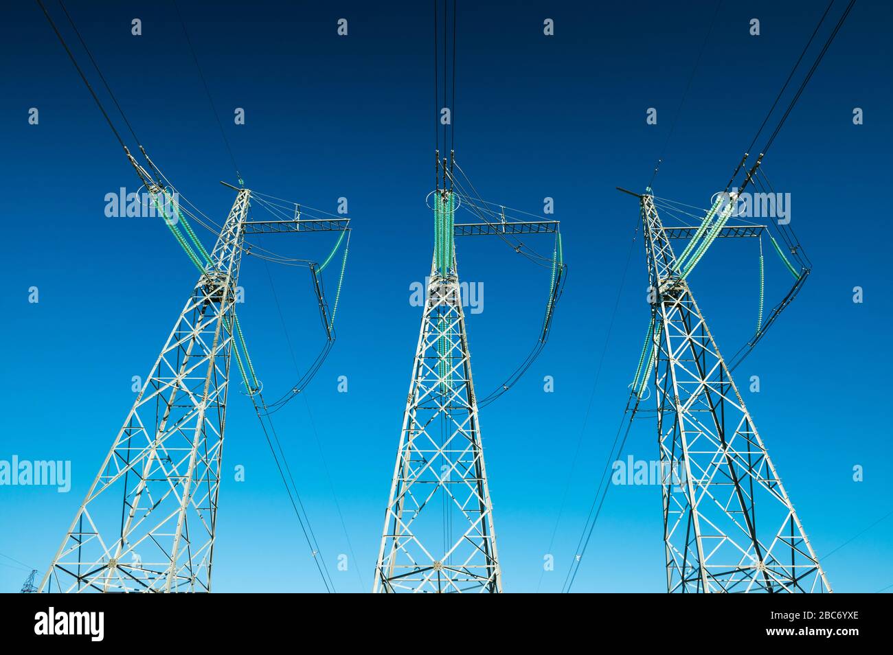 Electricity pylons in wide angle perspective, high voltage power lines ...