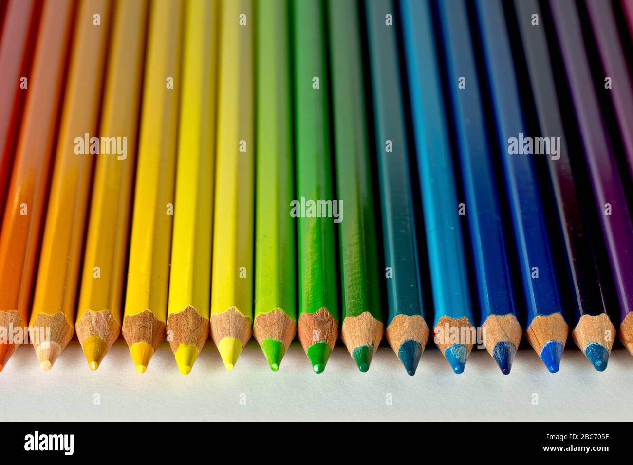 Close up still life of coloured pencils arranged in the colours of the ...