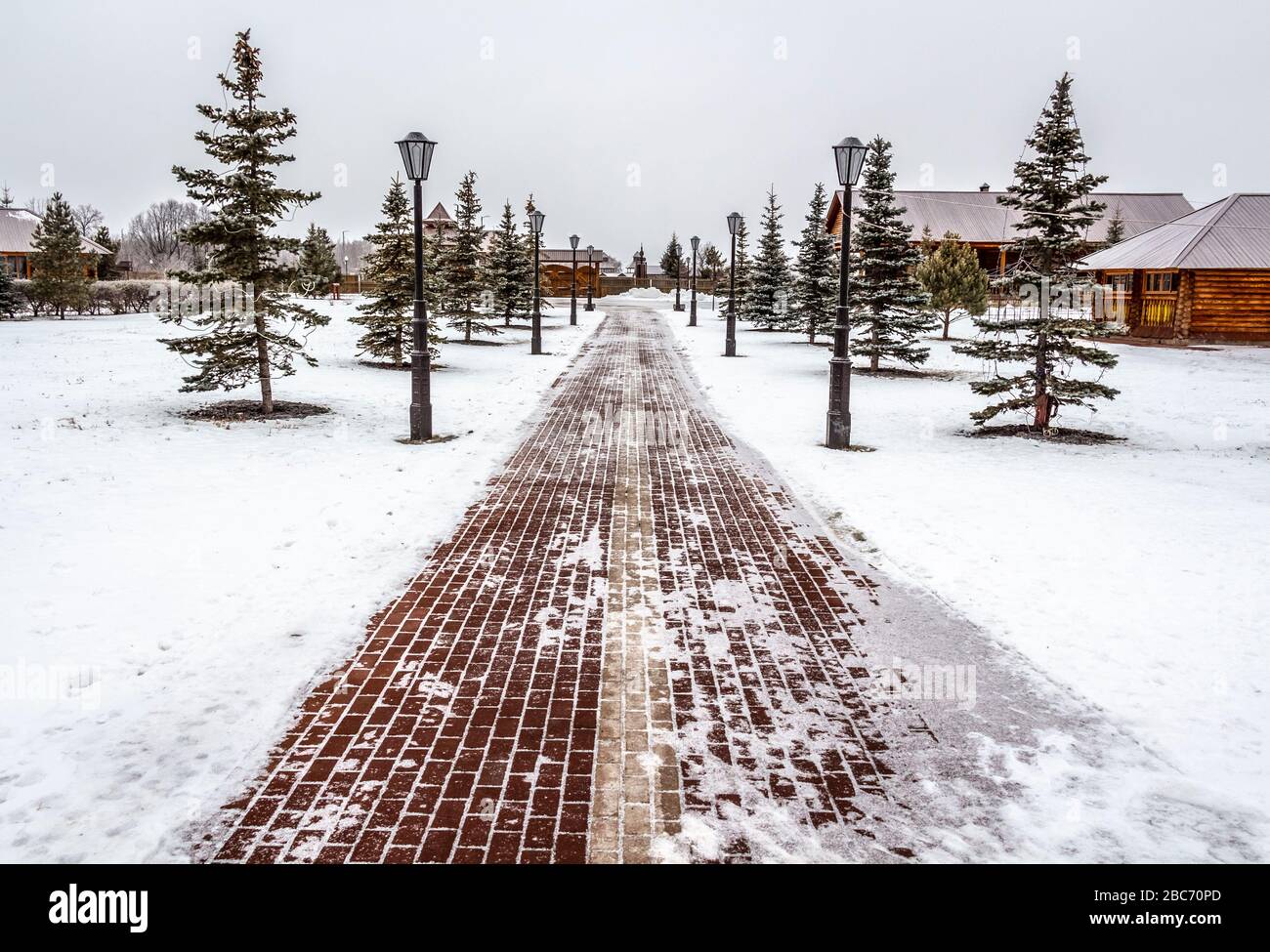 Snow covered sidewalk made of red pavers Stock Photo - Alamy