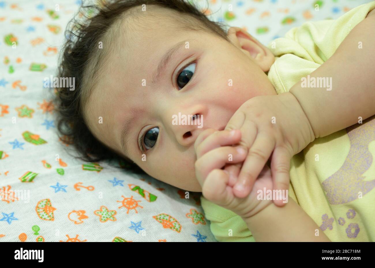 Newborn baby playing on bed Stock Photo - Alamy