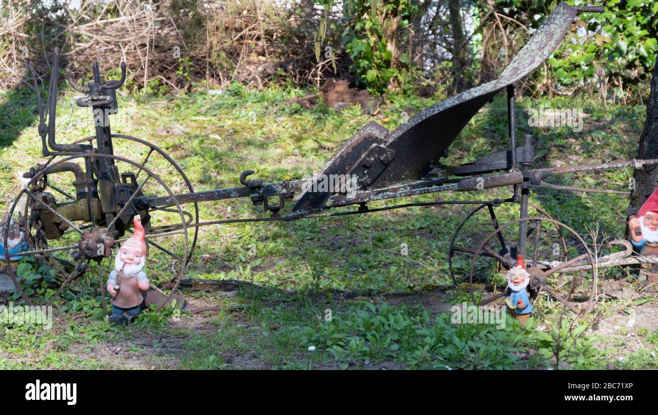 Old agricultural machine owned by garden gnomes Stock Photo - Alamy