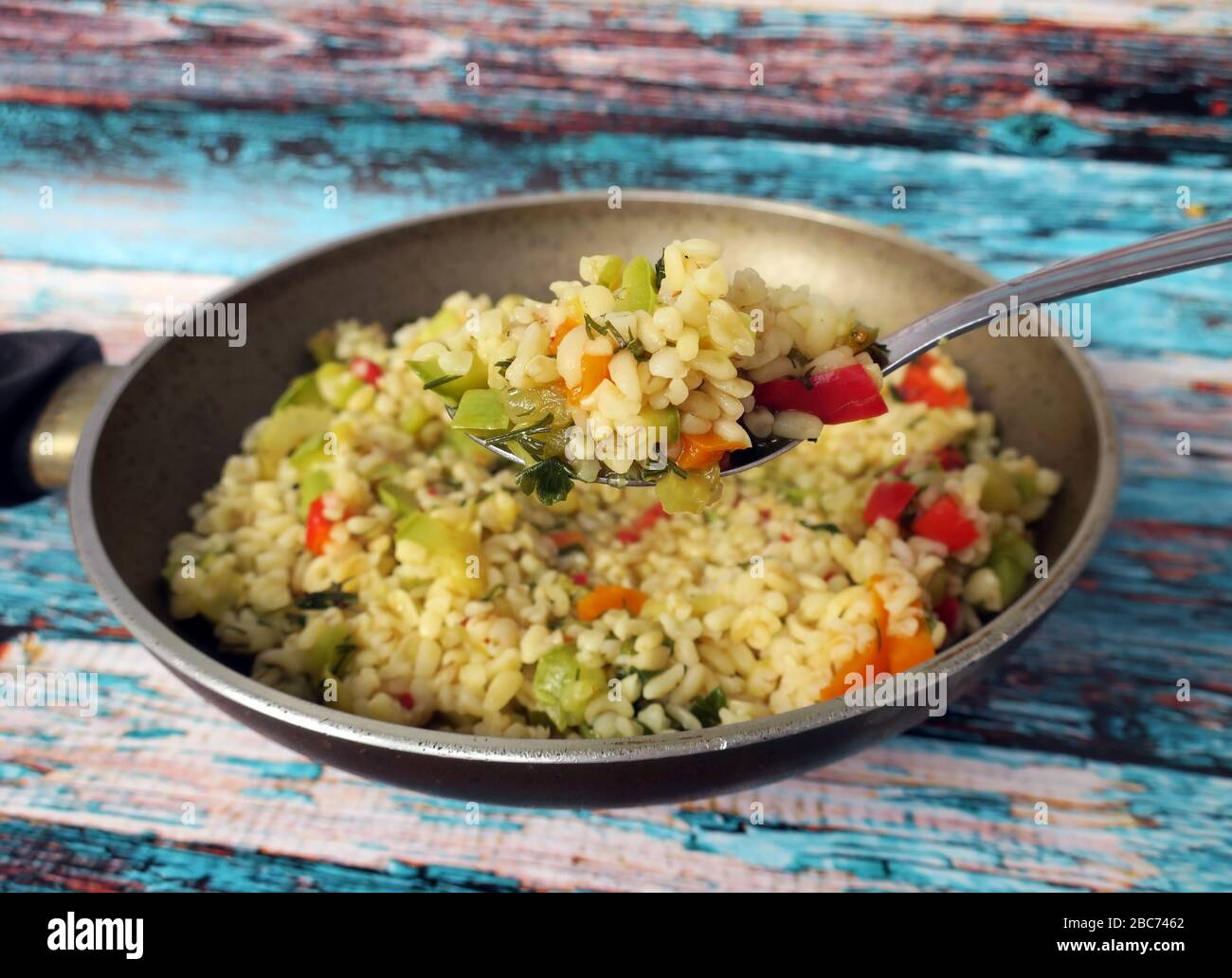 Boiled bulgur with vegetables in a tablespoon in a pan Stock Photo - Alamy