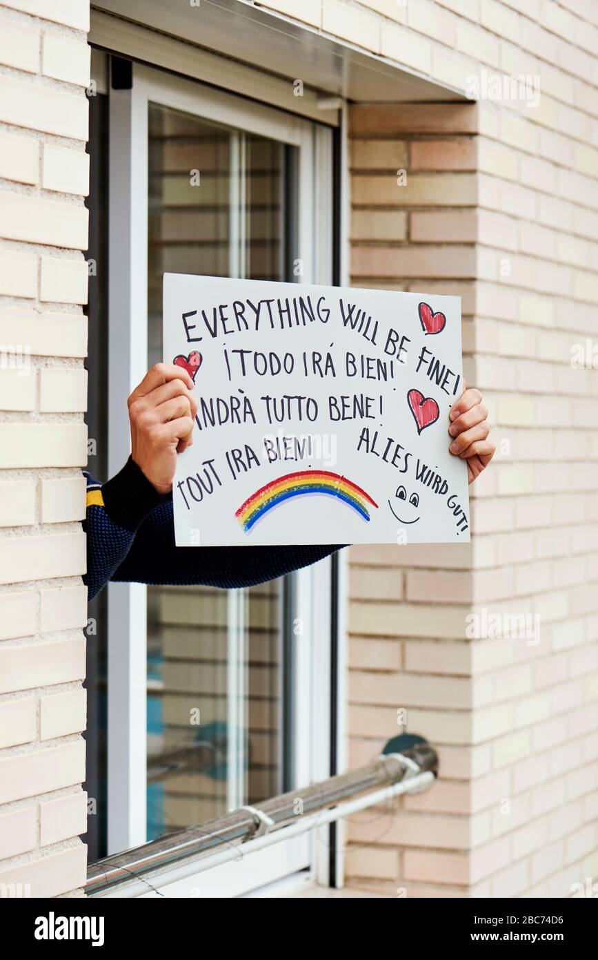 man leaning out the window showing a homemade sign with the text ...