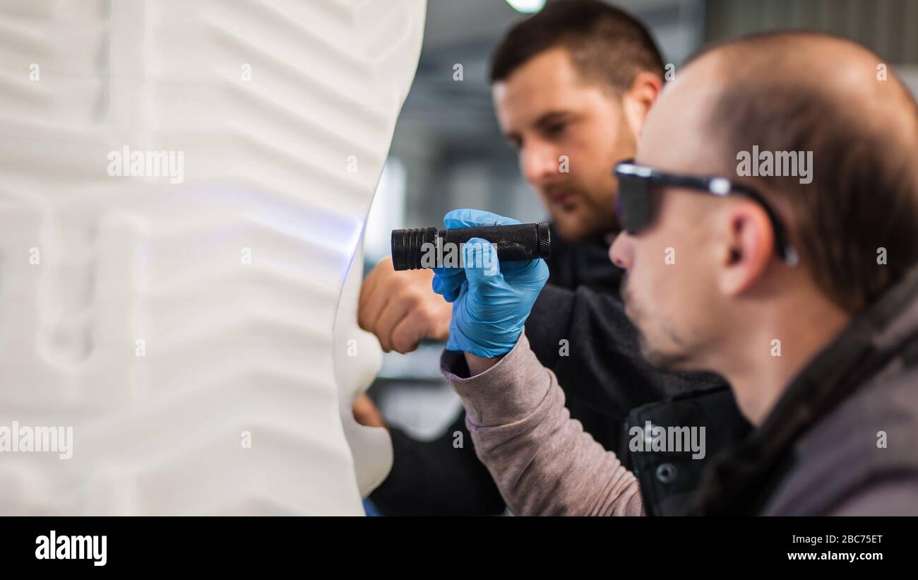 Technicians use UV lamp light for curing resin 3d print printed on ...