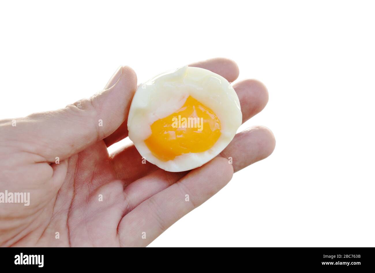 boiled egg half cut with creamy yolk holding on hand in white background Stock Photo - Alamy