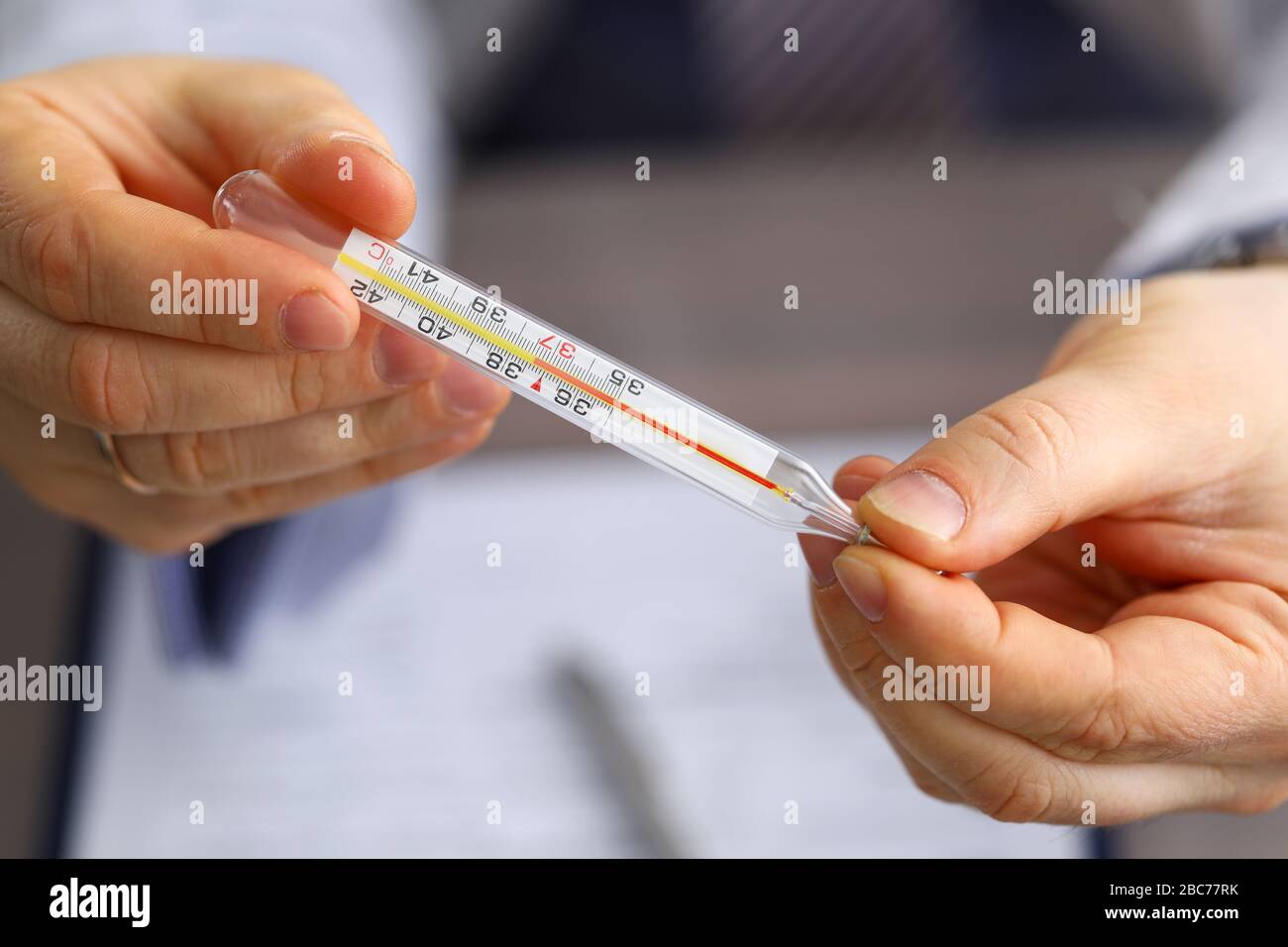 Male doctor holding in hand thermometer Stock Photo - Alamy