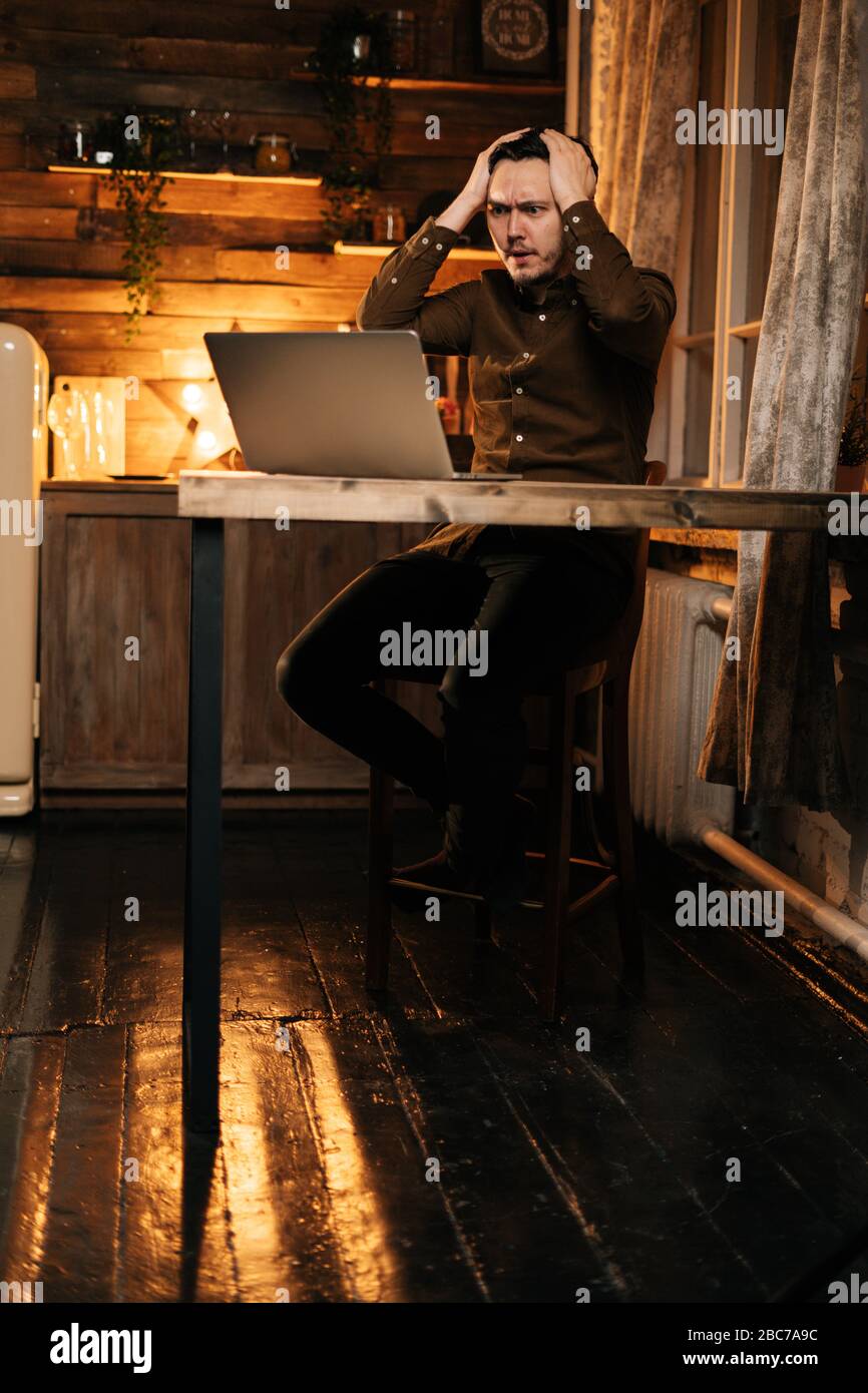 Shocked young man with shocked expression looking at screen laptop ...