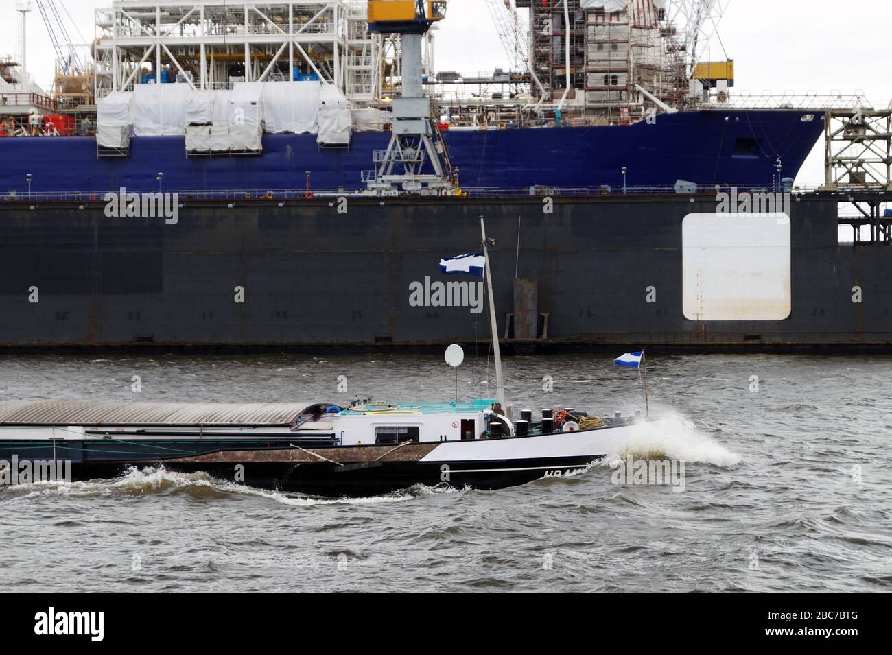 Photography of a small freighter on a river against floating dock Stock ...