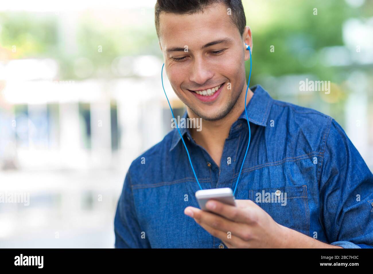 Man listening to music on mobile phone Stock Photo - Alamy