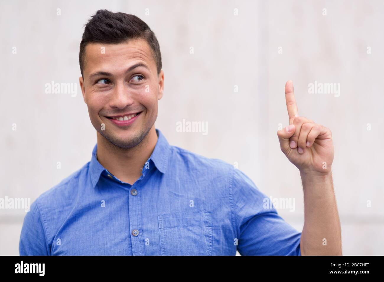 Young man pointing up Stock Photo - Alamy