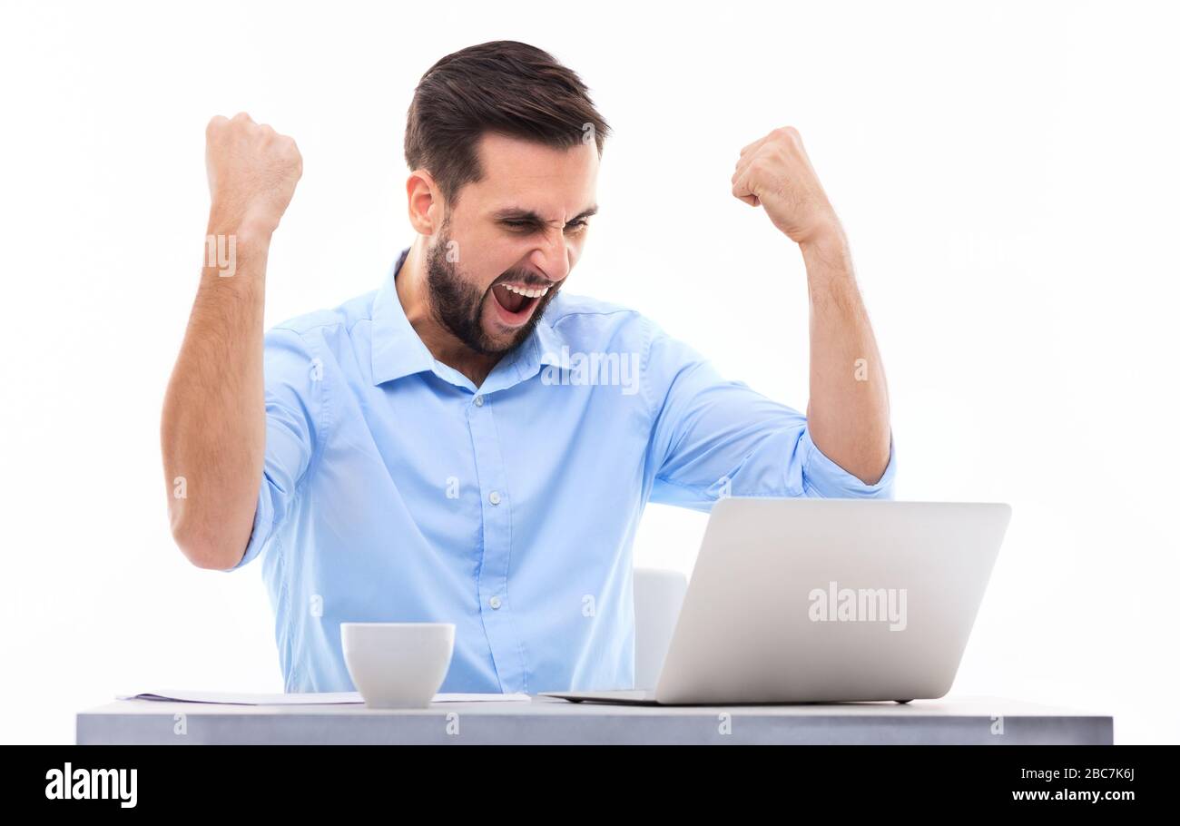 Man in front of laptop with arms raised Stock Photo - Alamy