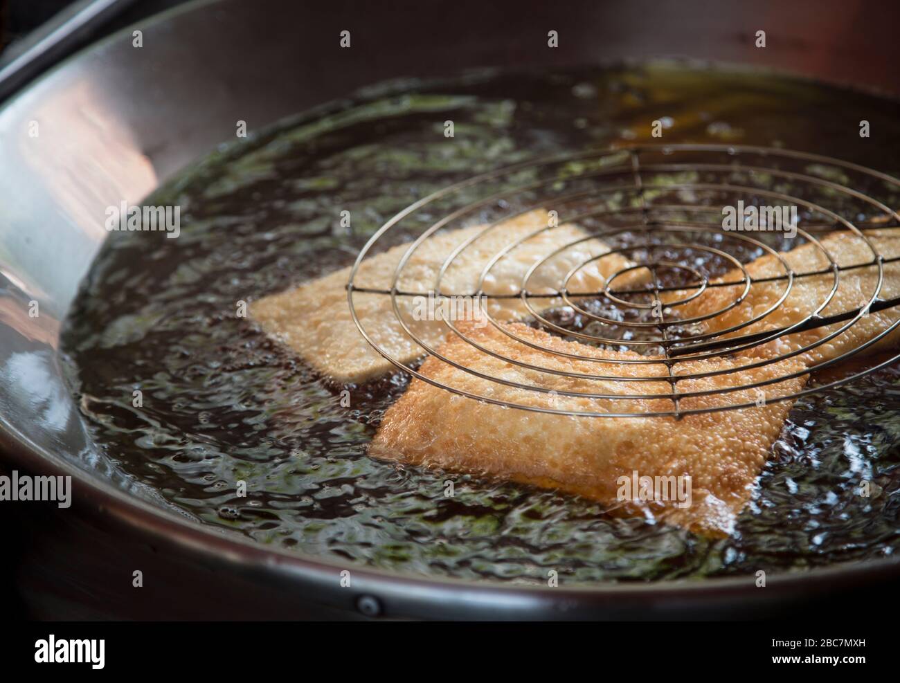 Pastels, a Brazilian street food speciality are deep fried at a street ...