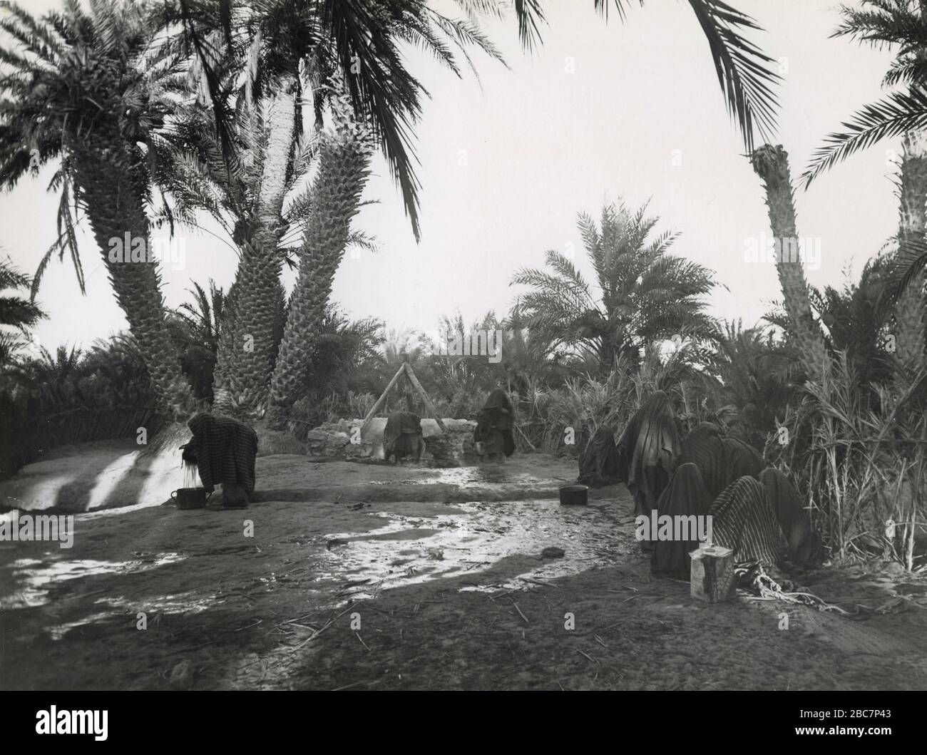 Women taking water at the source in the desert oasis of Marada, Libya ...