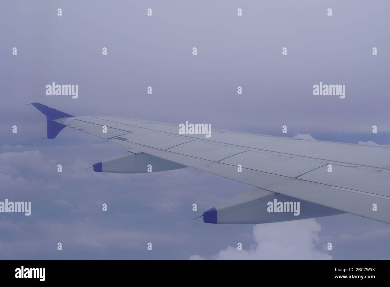 Wing of an airplane flying above the rainy dark clouds. Shot of Plane ...
