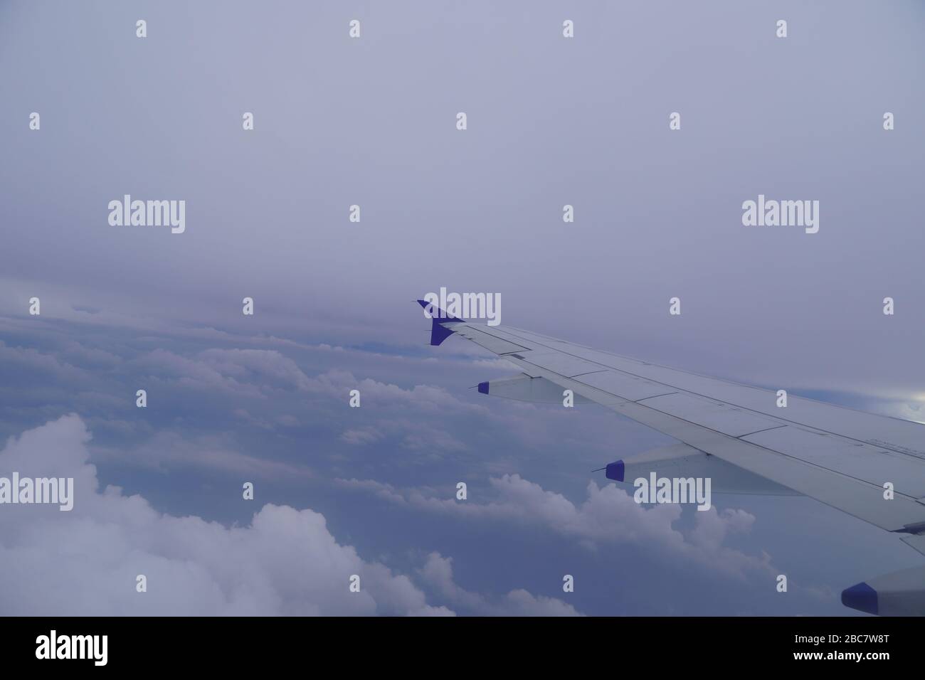 Wing of an airplane flying above the rainy dark clouds. Shot of Plane ...