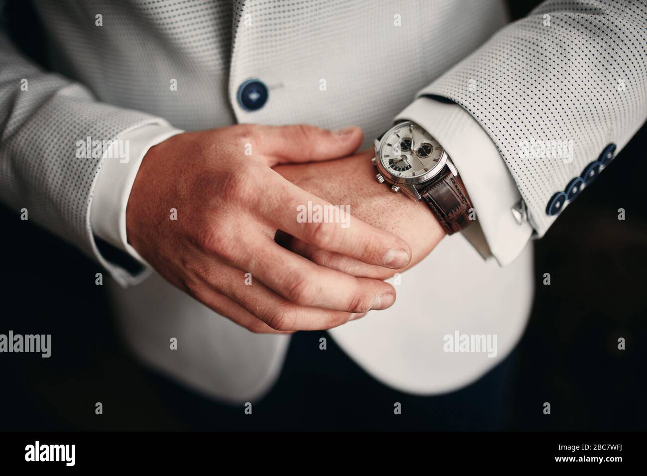 businessman checking time on his wrist watch, man putting clock on hand ...