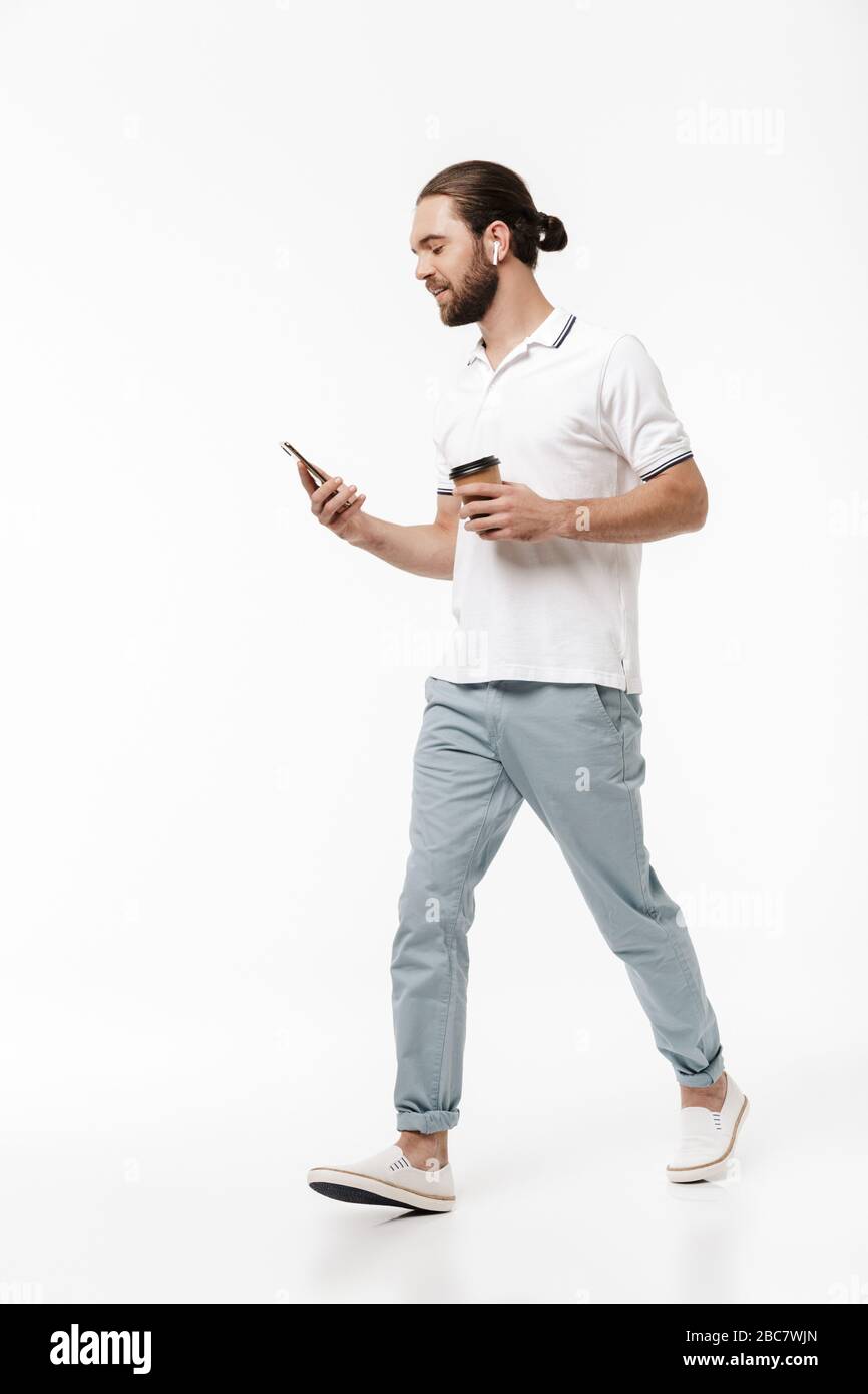 Photo of a young positive happy handsome bearded man walking isolated ...