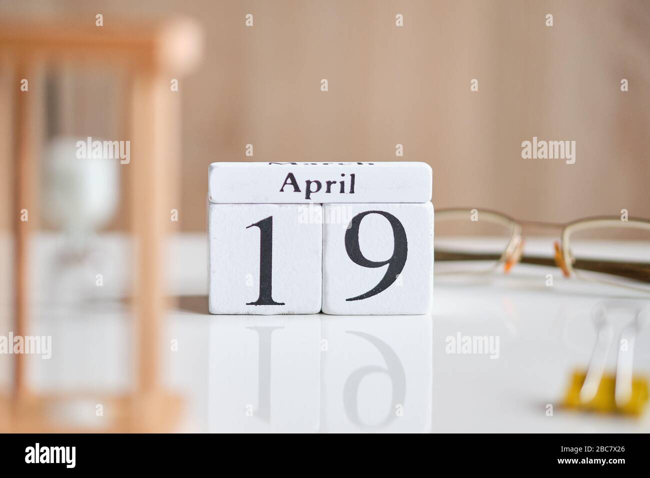 Date on white wooden cubes - the nineteenth, 19 April on a white table ...