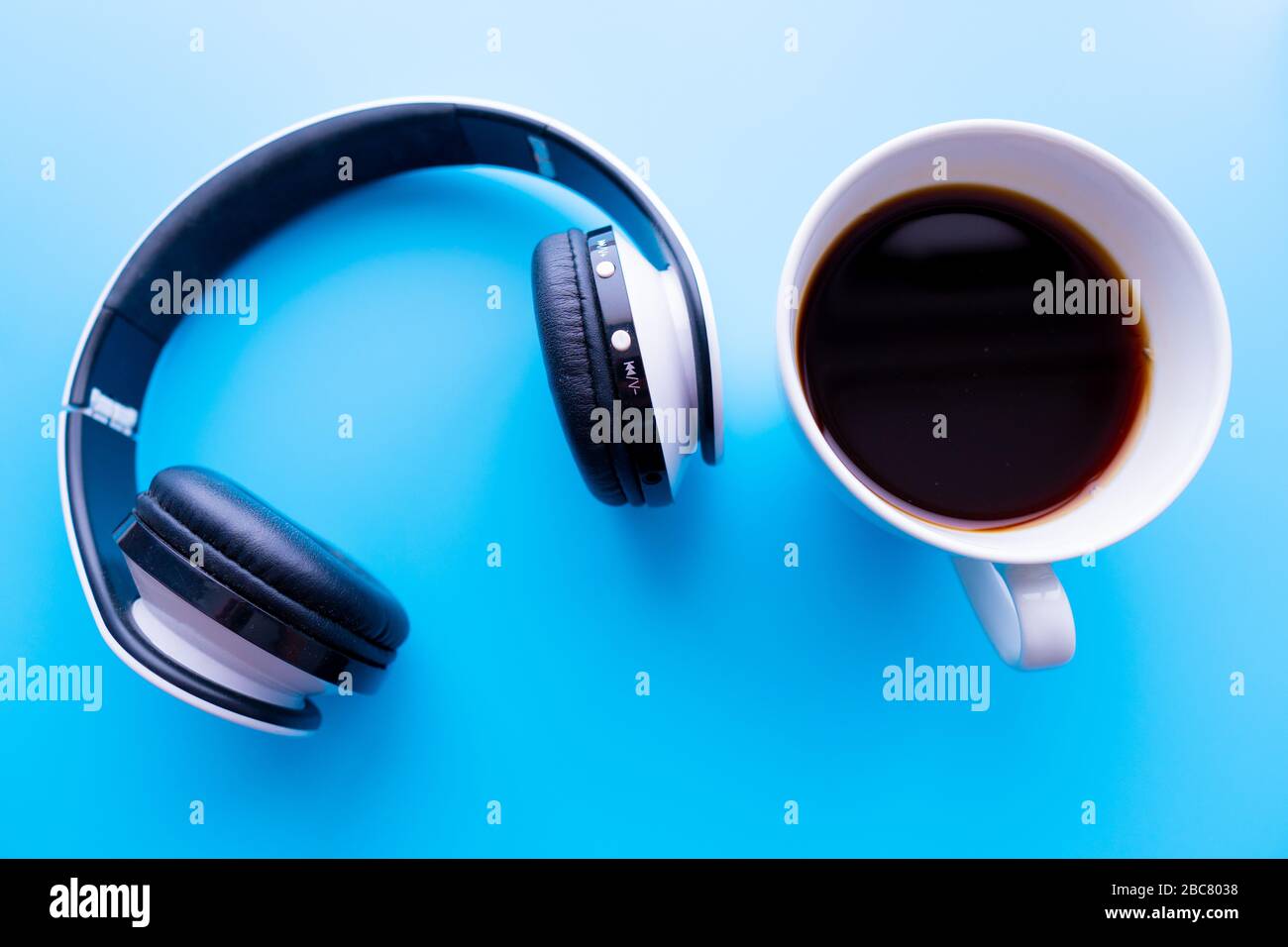 Headphones and coffee cup on blue background table. Music concept. Top ...
