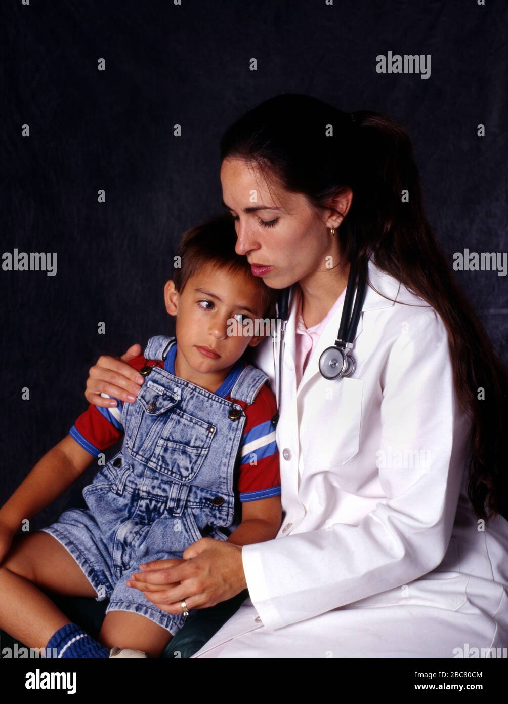 A nurse comforts a young boy Stock Photo - Alamy