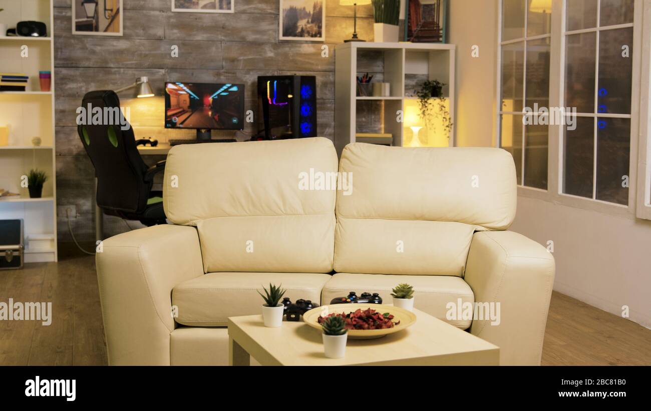 Empty room with couch in the middle and gaming computer in the ...