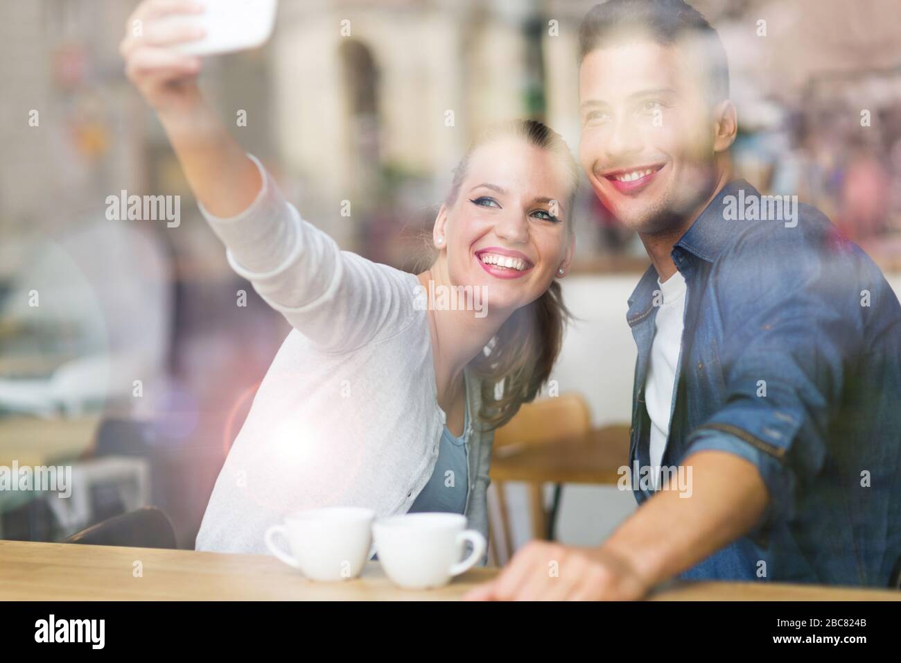 Young couple seen through cafe window Stock Photo - Alamy