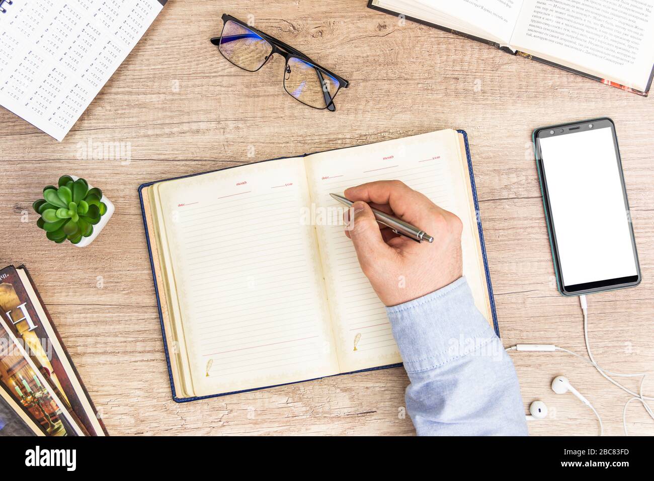 Study concept flat lay man is going to write something on his notebook ...